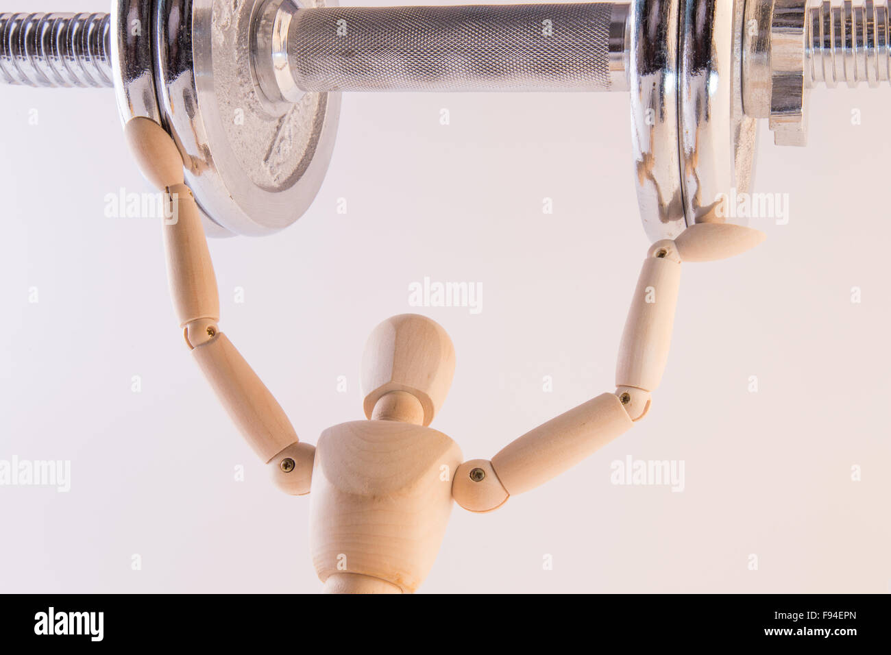 Puppet carrying heavy metal weight on a white background Stock Photo ...
