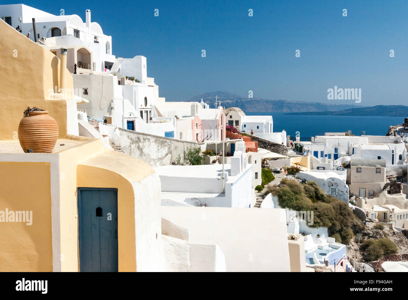 Santorini, Oia. View along town, built on sloping cliff, with ...