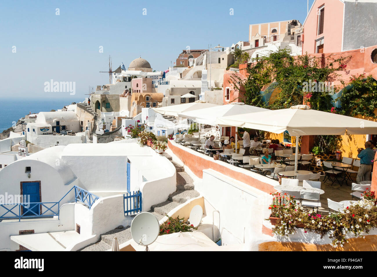 Santorini, Oia. View along town, built on sloping cliff, with ...