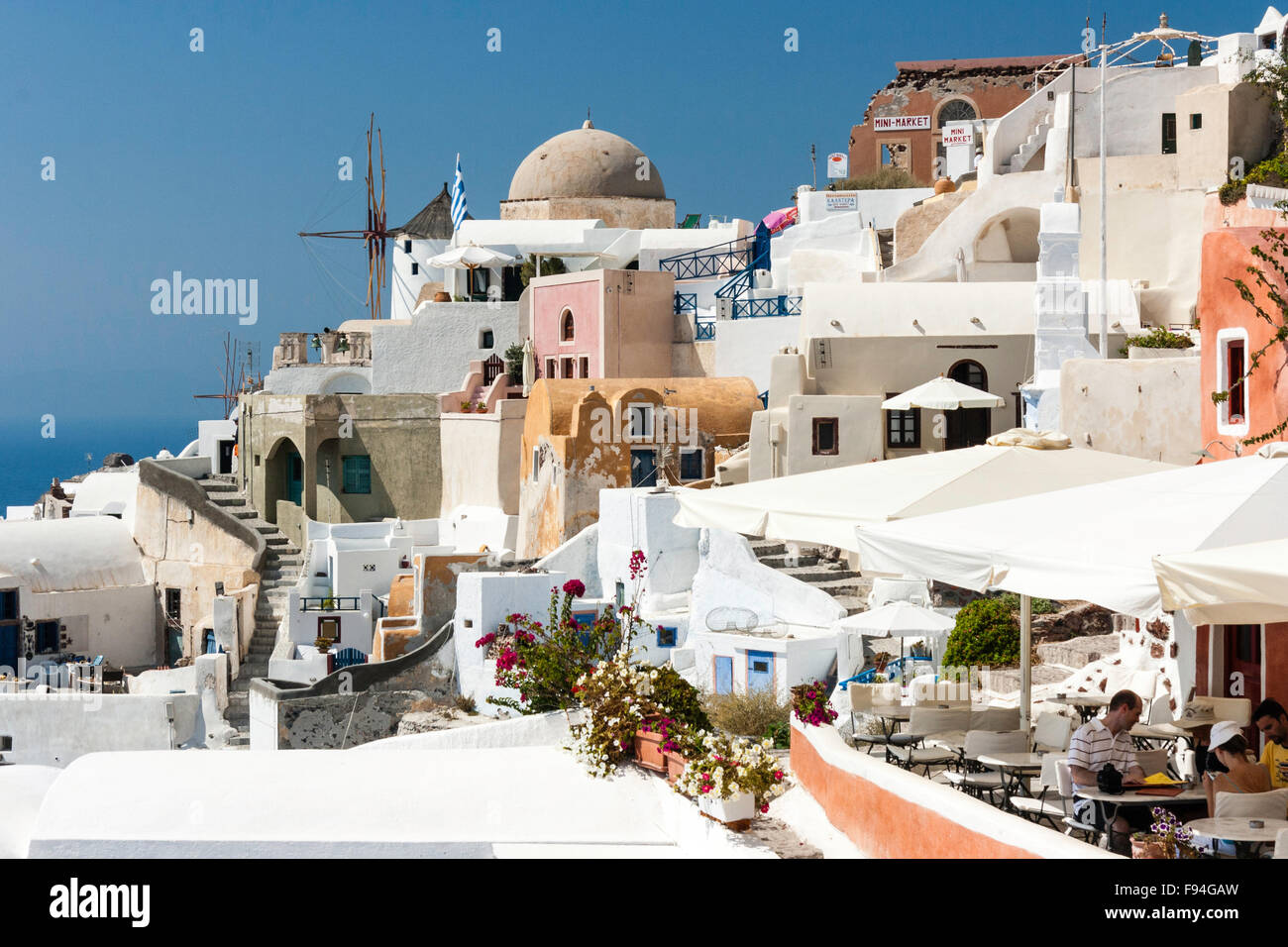 Santorini, Oia. View along town, built on sloping cliff, with ...