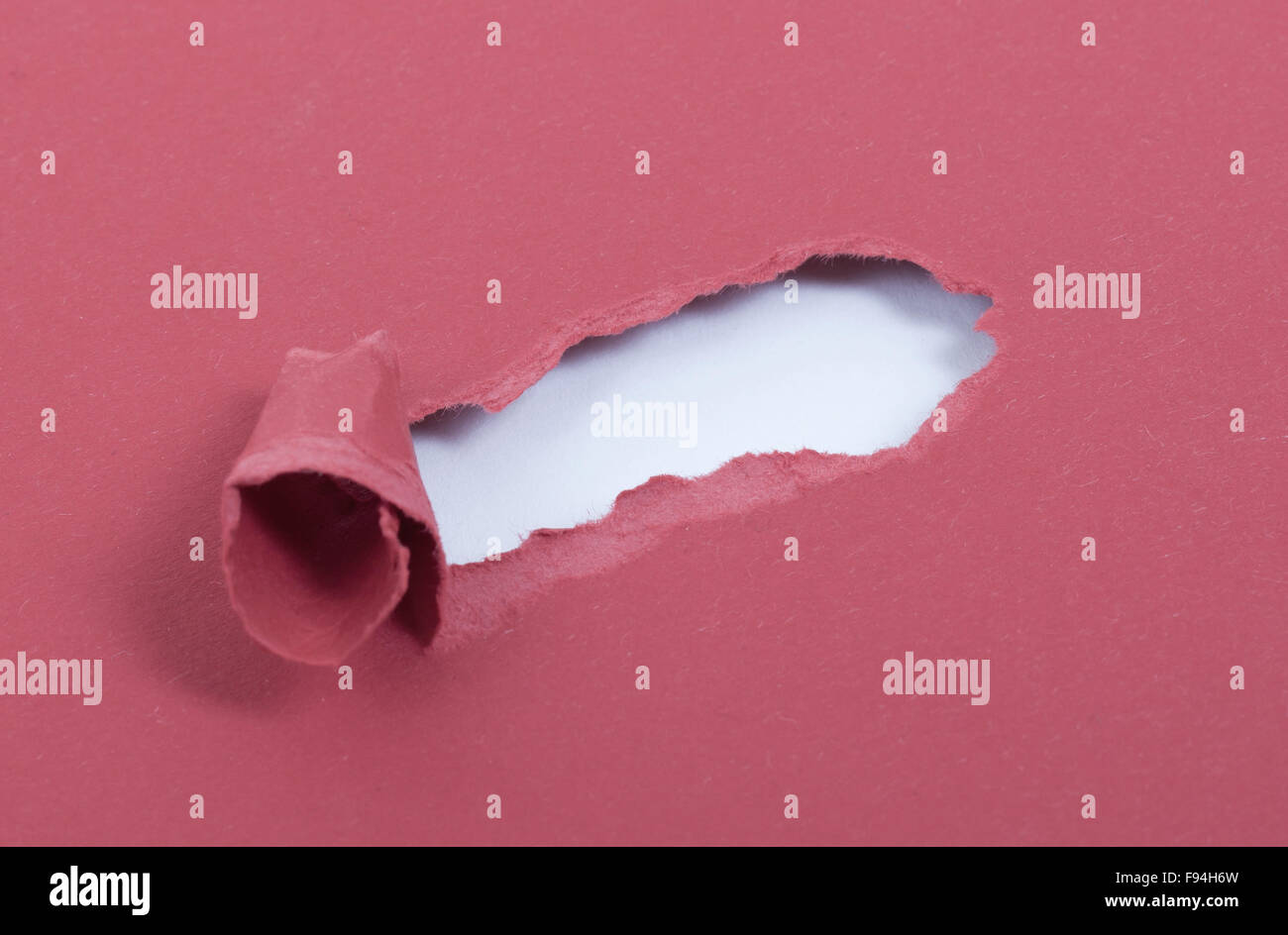 Hole in the paper with torn sides Stock Photo - Alamy