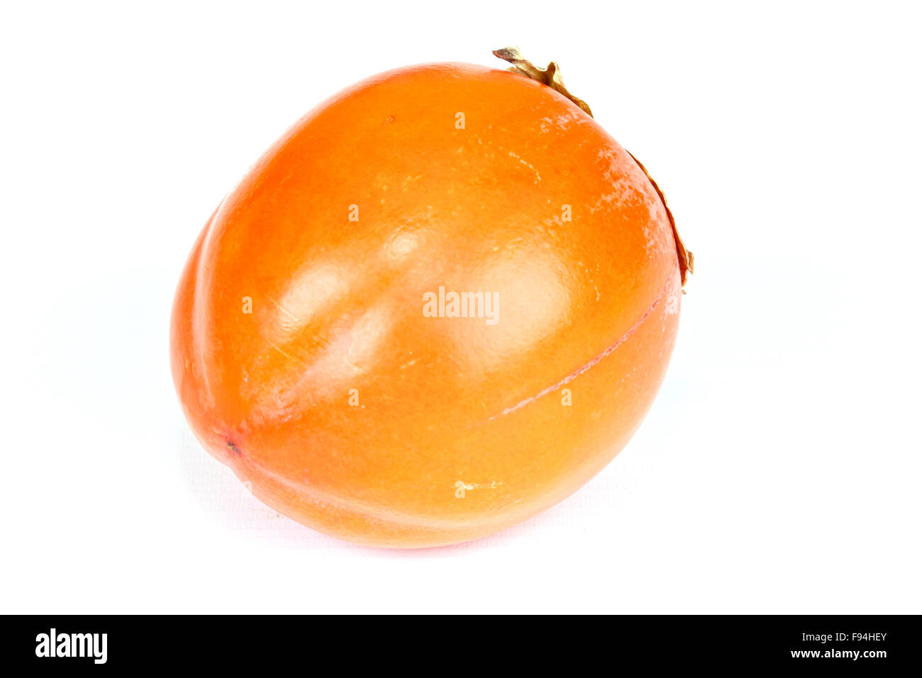 A single persimmon laying on a white background Stock Photo - Alamy