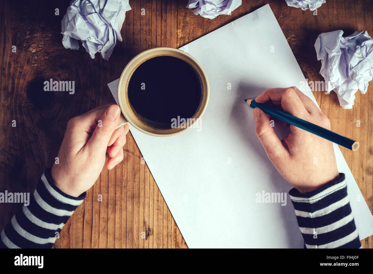 Female writer drinking cup of coffee, top view of female hands holding ...