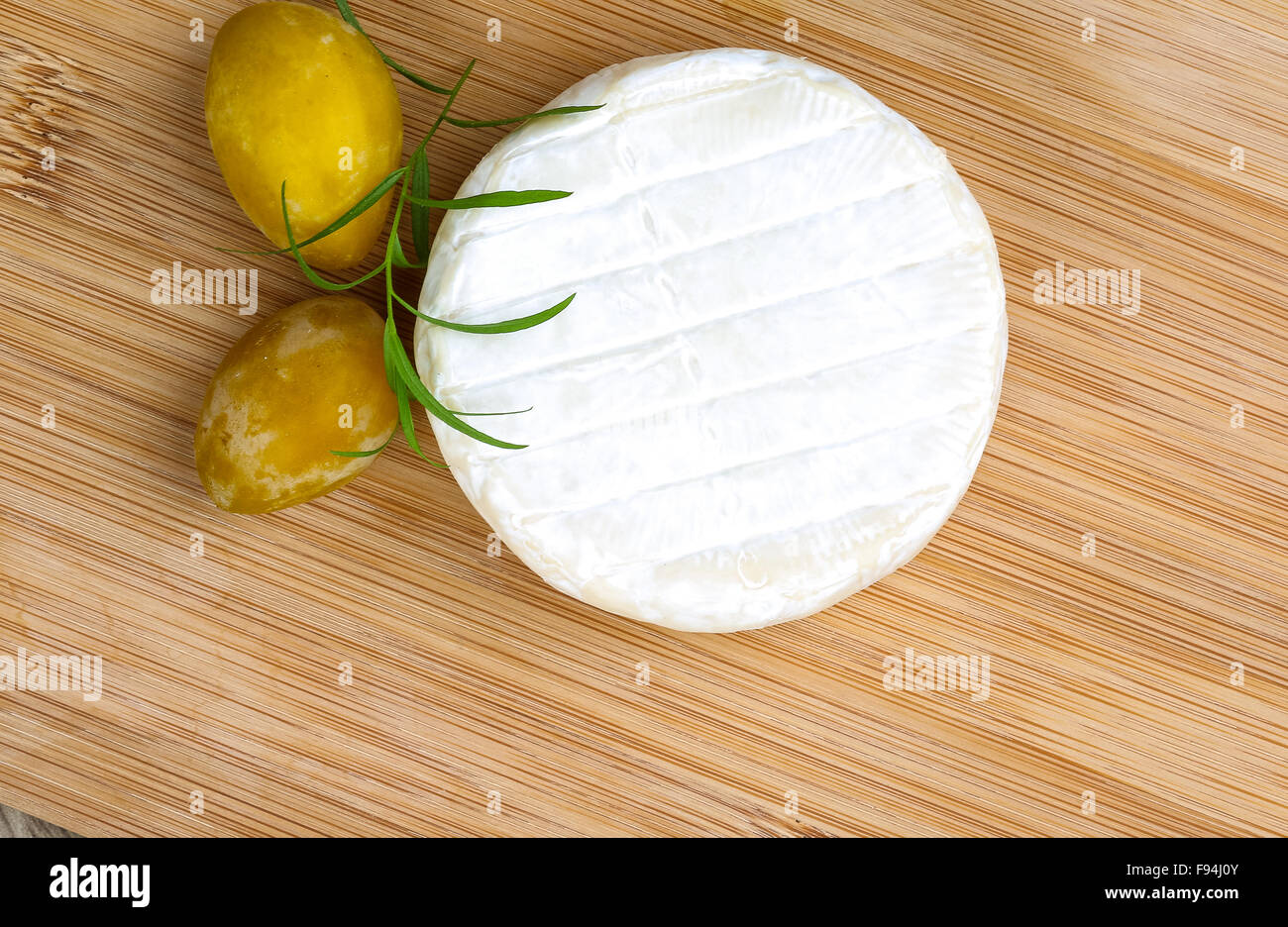 Round Brie cheese with yellow plums and estragon Stock Photo - Alamy