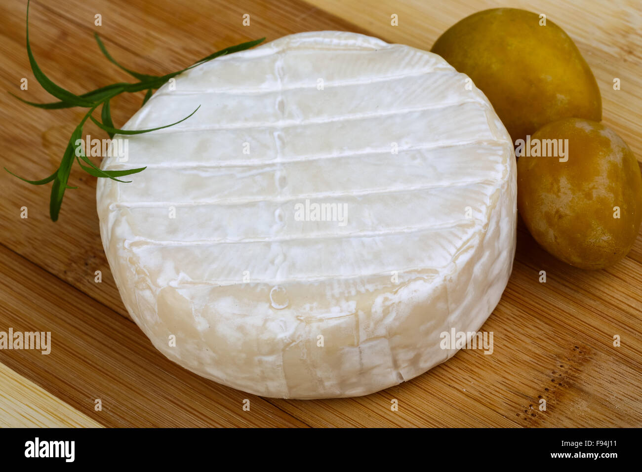 Round Brie cheese with yellow plums and estragon Stock Photo - Alamy
