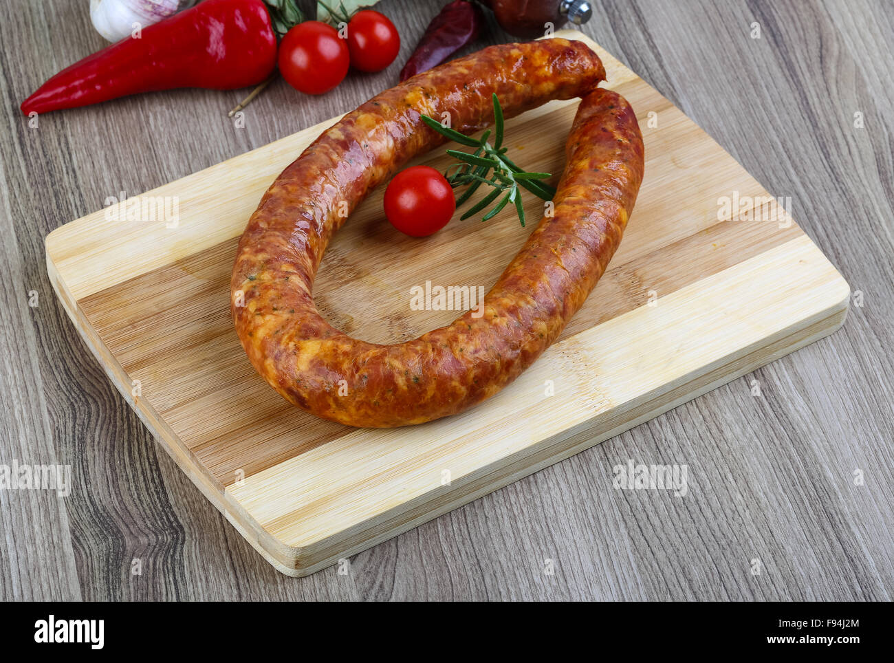 Sausage ring with rosemary and pepper on the wood background Stock ...
