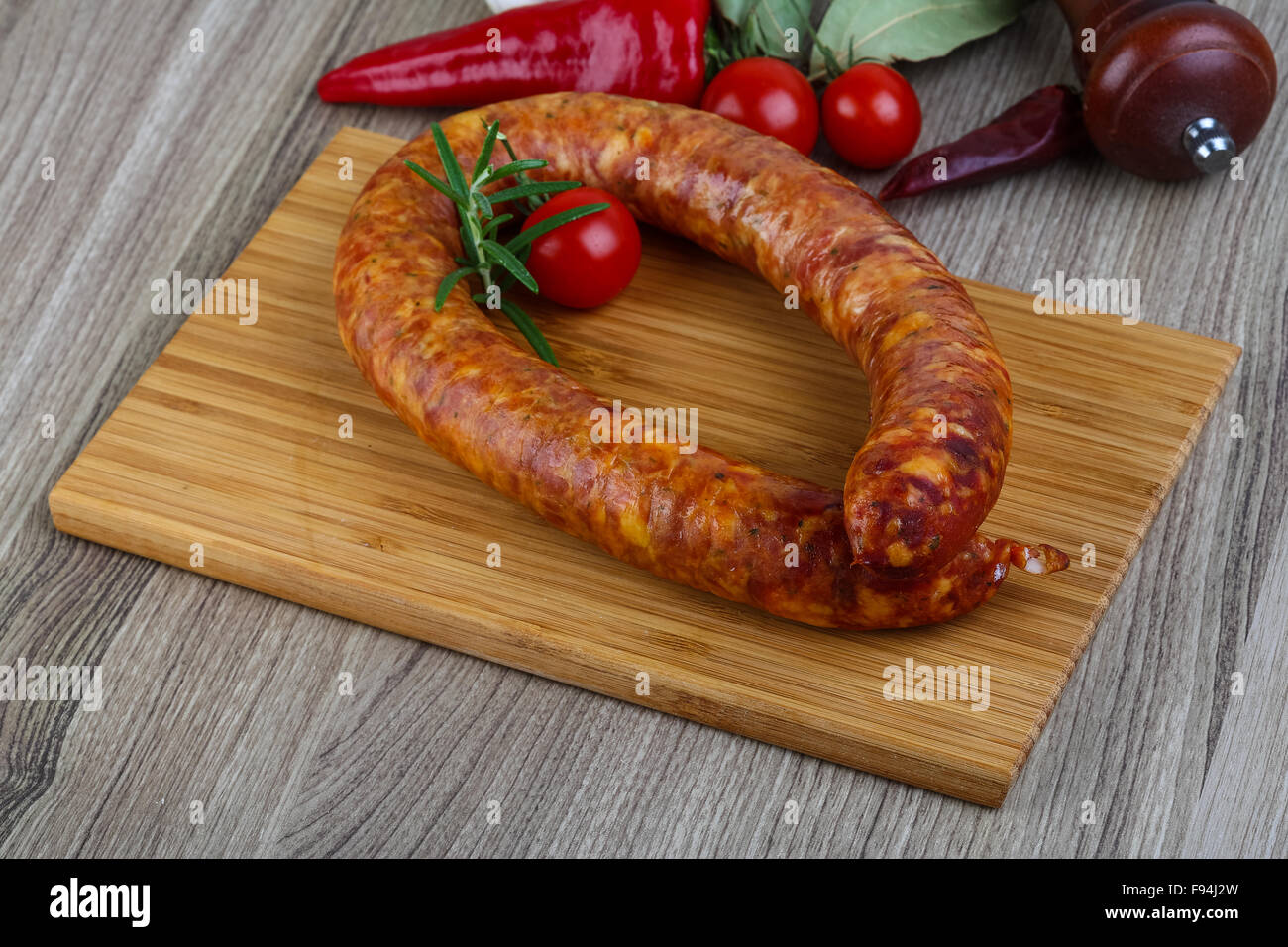 Sausage ring with rosemary and pepper on the wood background Stock ...
