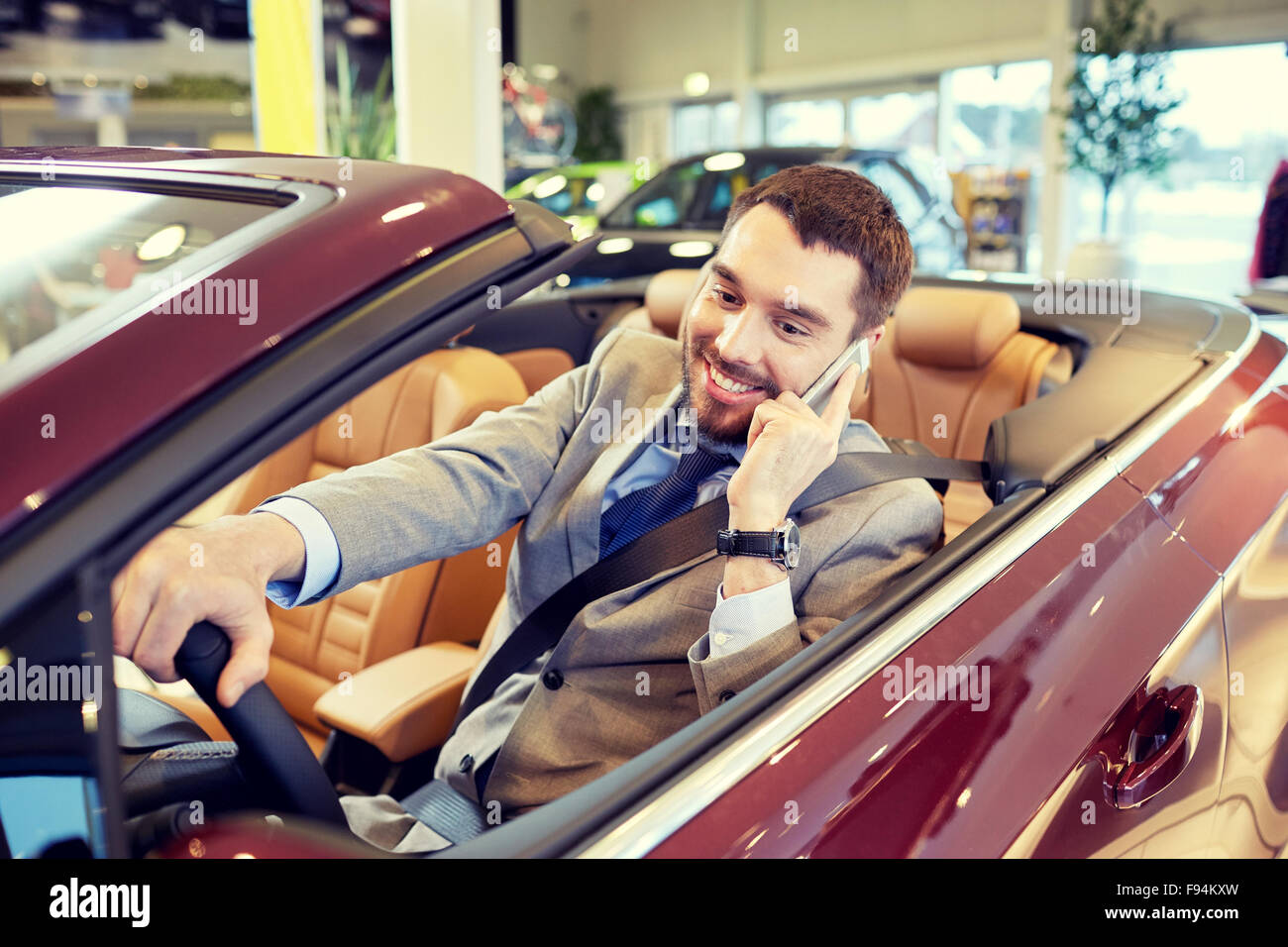 happy man sitting in car at auto show or salon Stock Photo - Alamy