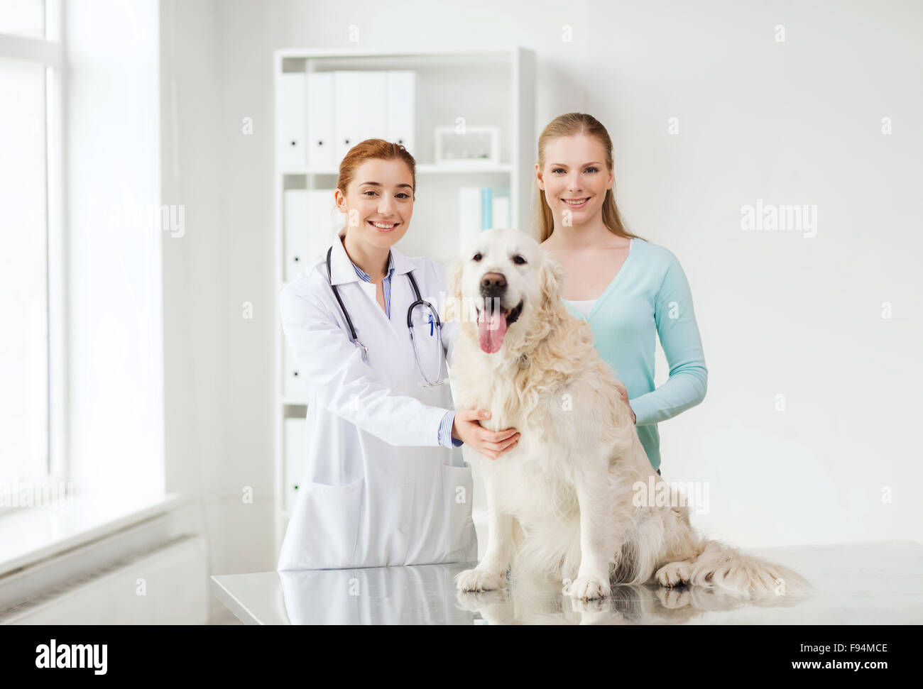 happy woman with dog and doctor at vet clinic Stock Photo - Alamy