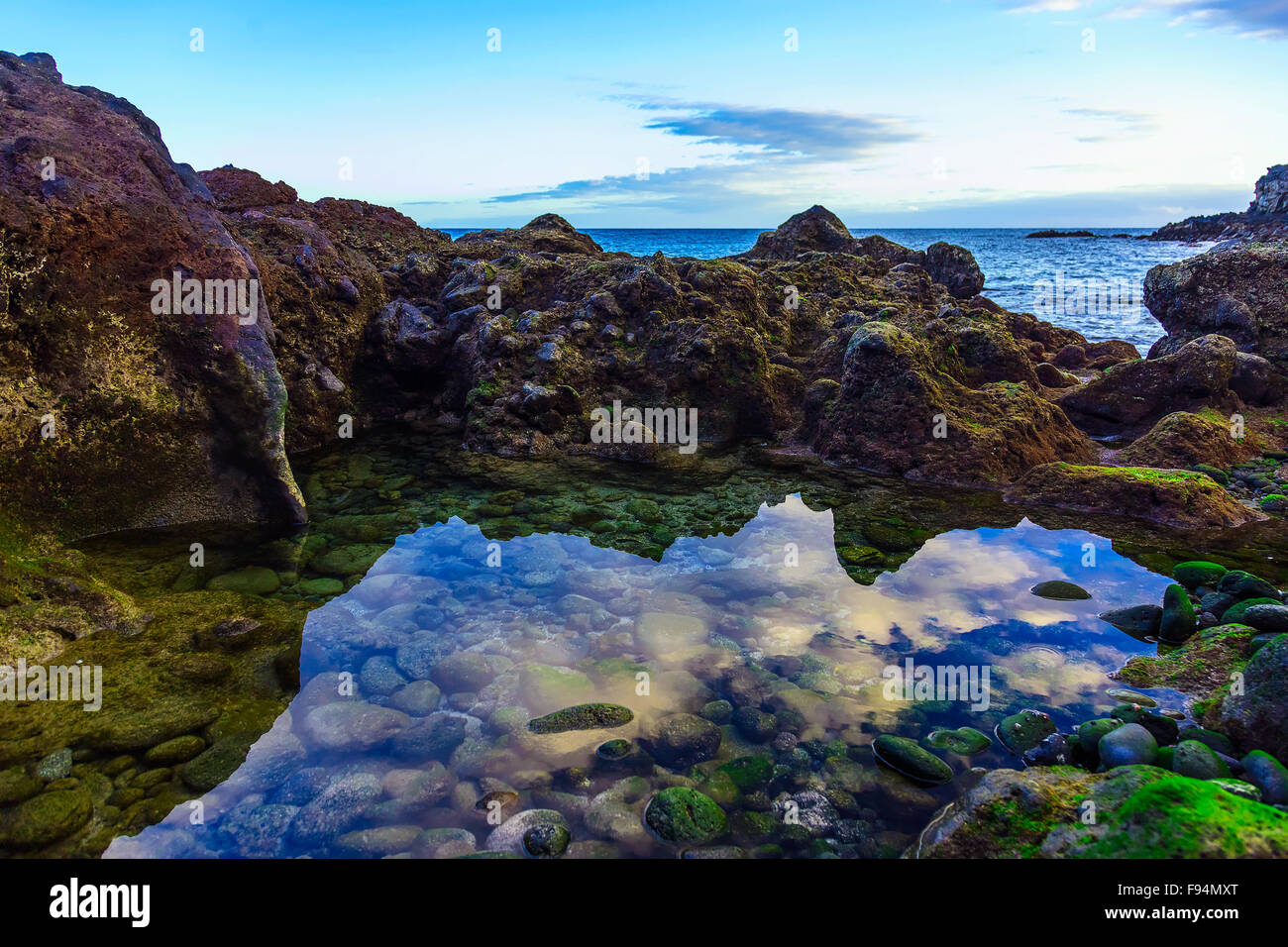 Stone Coast of Atlantic Ocean with Sky Reflection in water on Canary ...