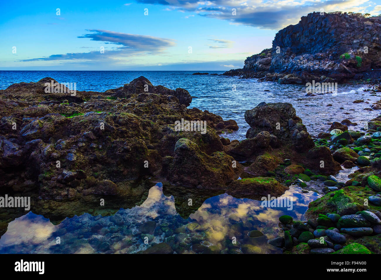 Stone Shore of Atlantic Ocean with Sky Reflection in water on Canary ...