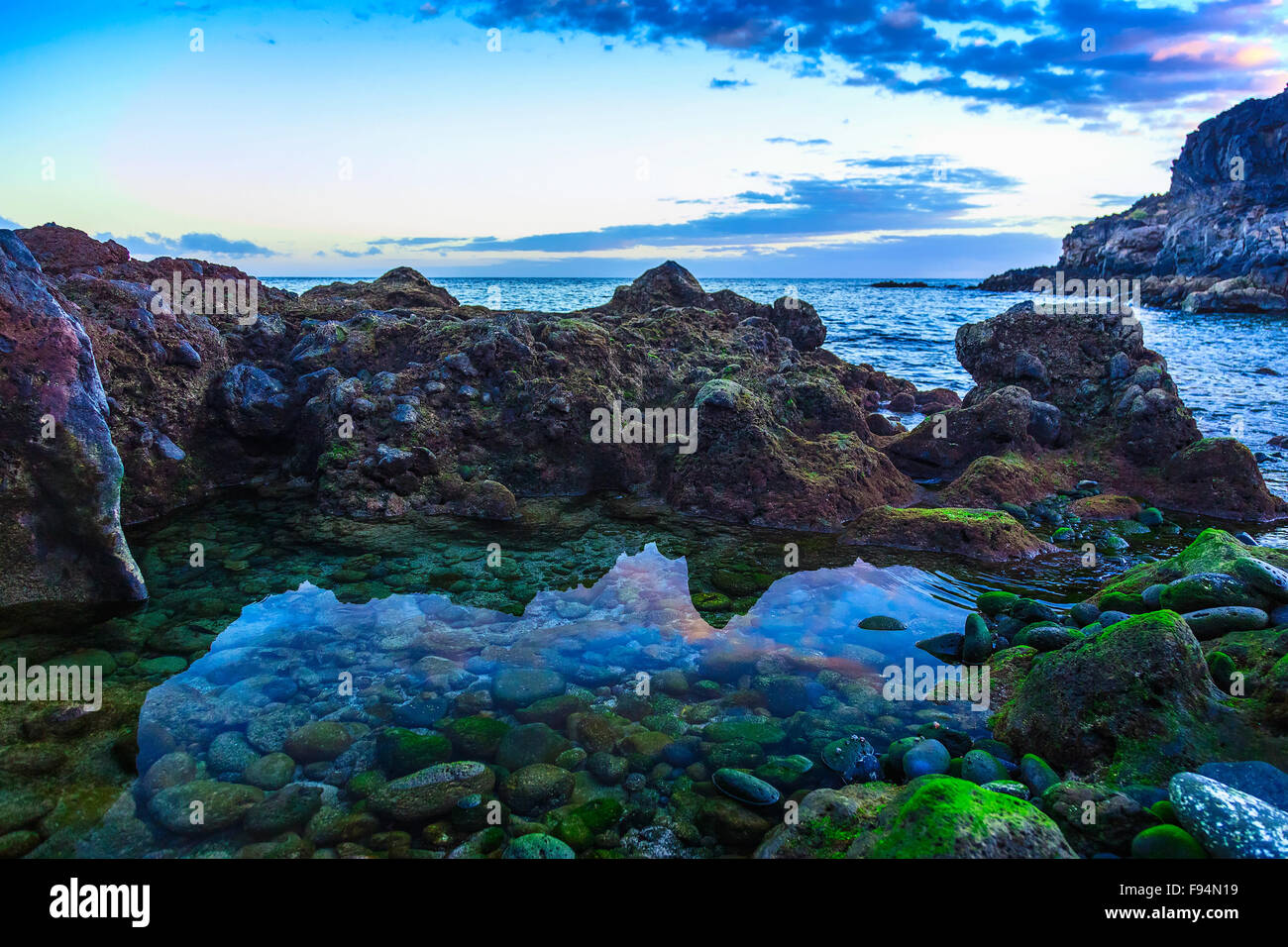 Stone Shore of Ocean with Sky Reflection in water on Tenerife Canary ...