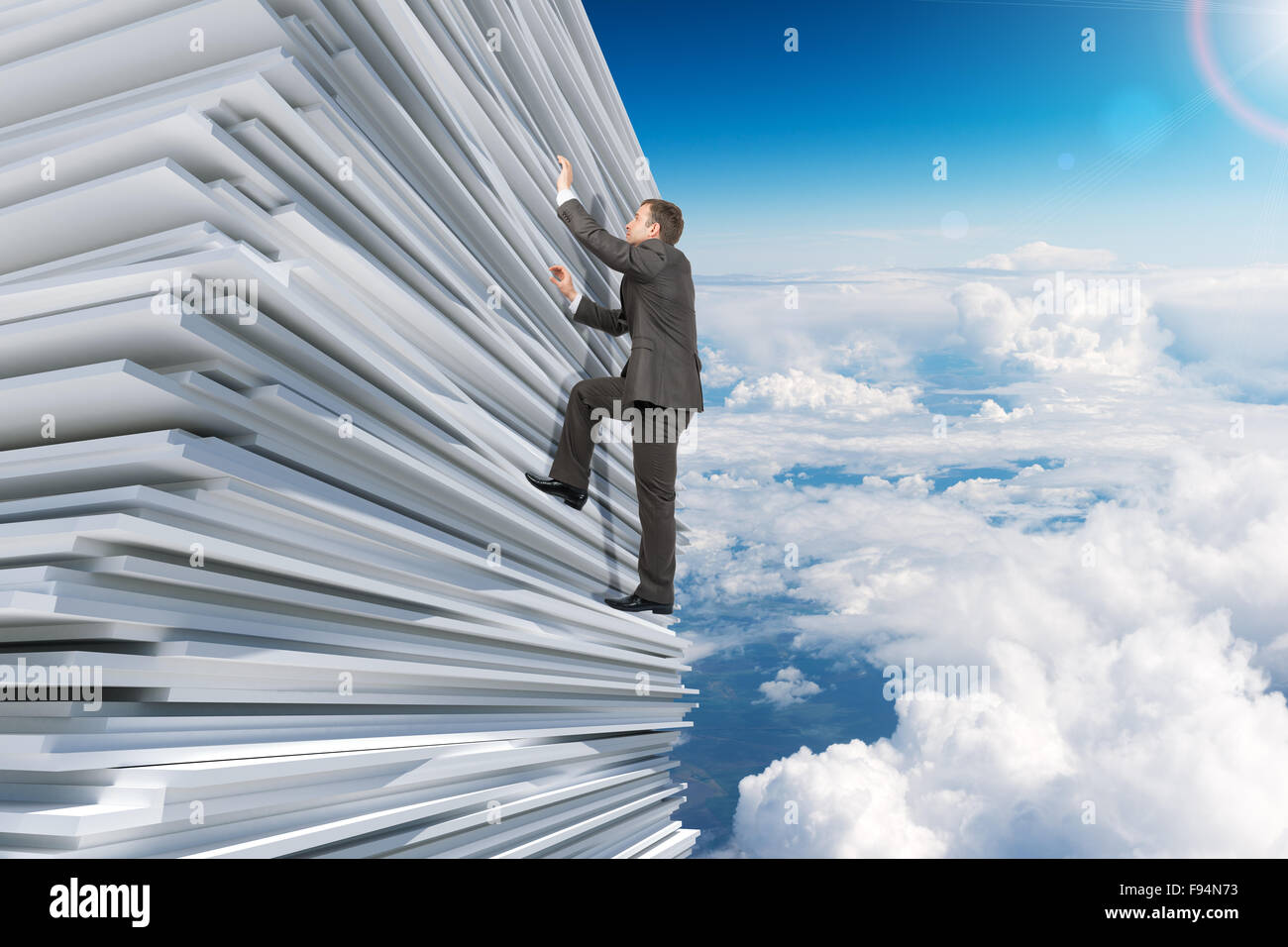 Businessman climbing up a huge stack of paper Stock Photo - Alamy