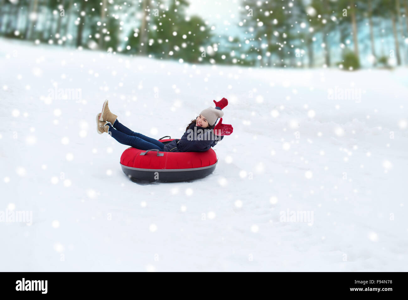 happy teenage girl sliding down on snow tube Stock Photo - Alamy