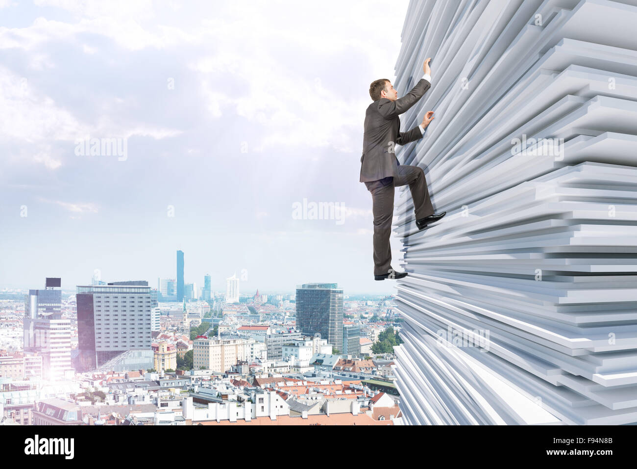 Businessman climbing up a huge stack of paper Stock Photo - Alamy