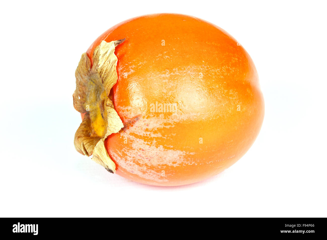 A single persimmon laying on a white background Stock Photo - Alamy
