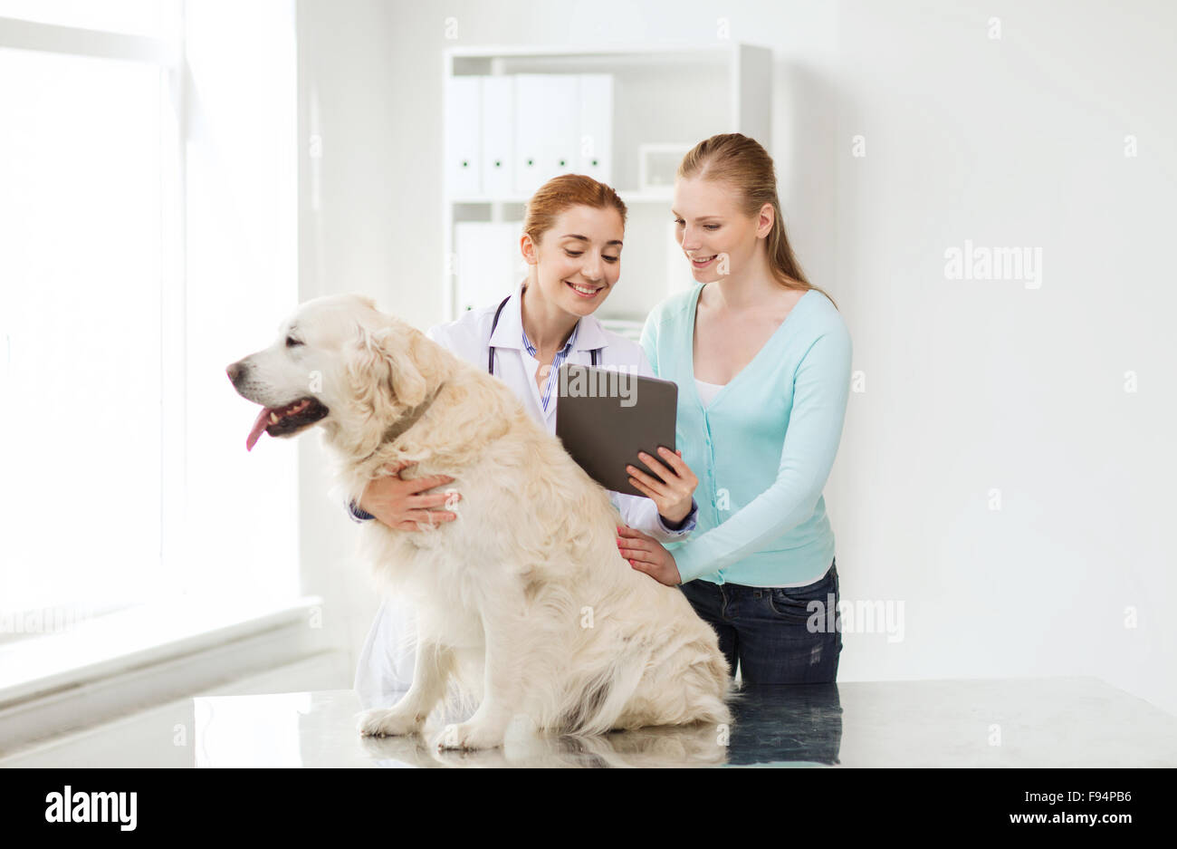 happy woman with dog and doctor at vet clinic Stock Photo - Alamy