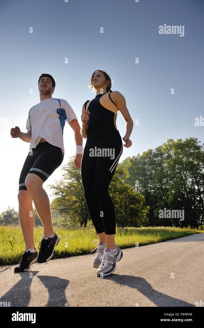 Young couple jogging in park at morning. Health and fitness Stock Photo ...