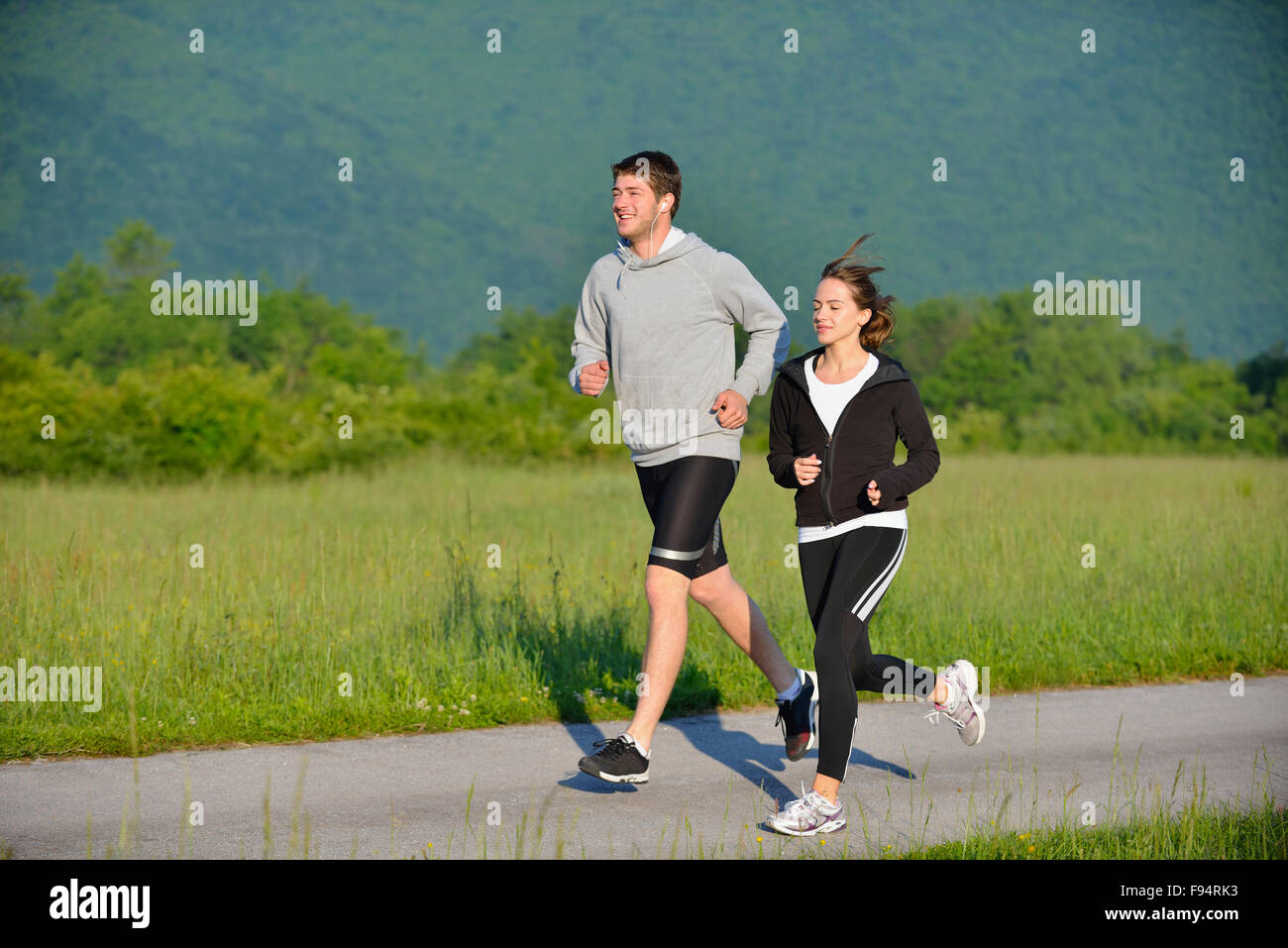 Young couple jogging in park at morning. Health and fitness Stock Photo ...