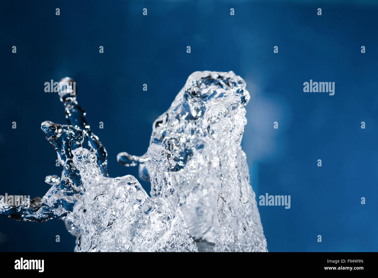 Water splash levitating in the air on blue Stock Photo - Alamy