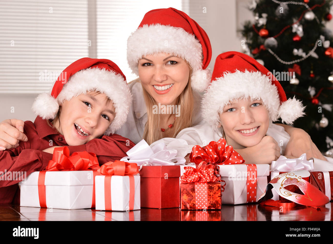 Mom and children in santa hats Stock Photo - Alamy