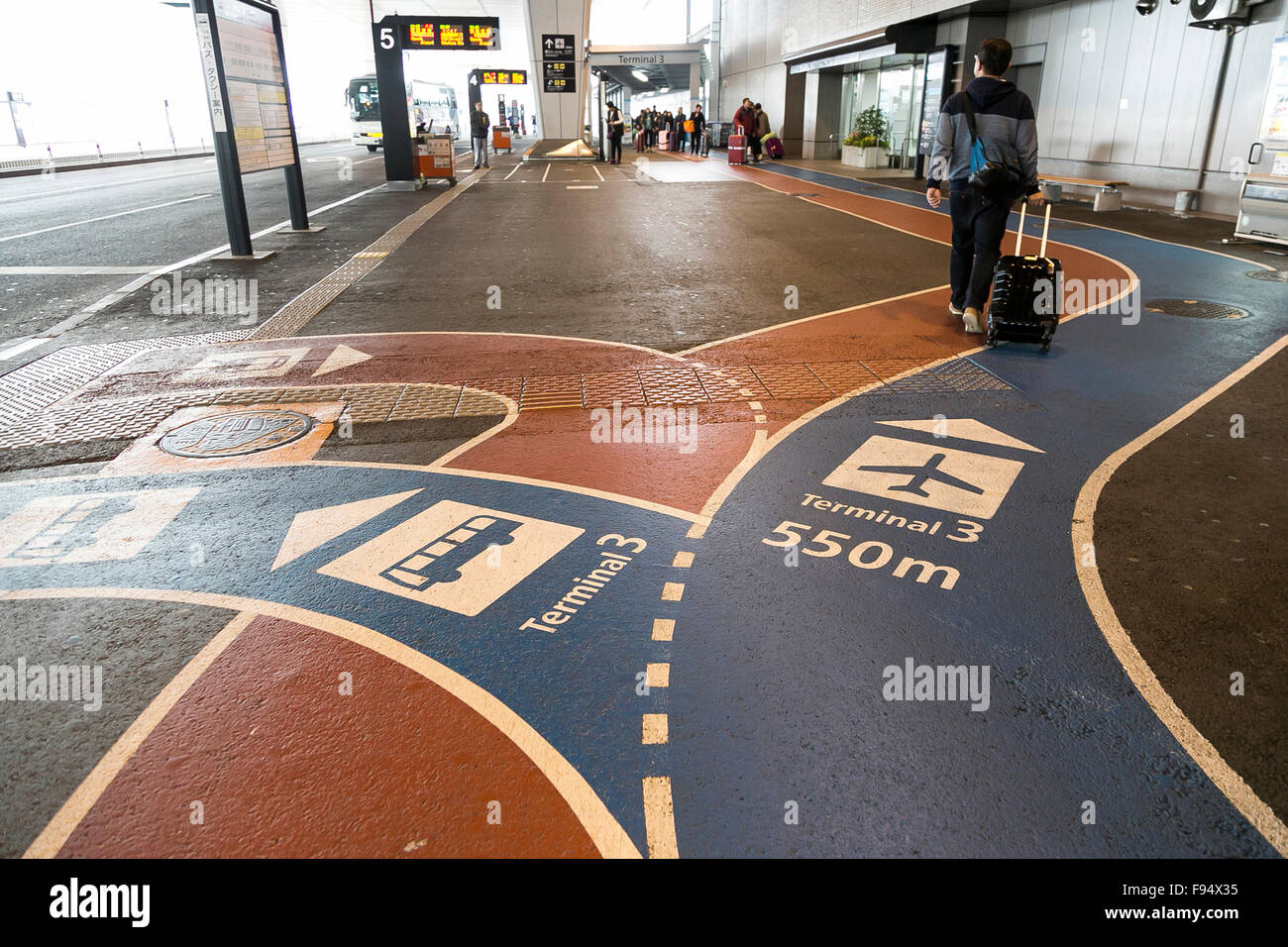 A passenger walks on a running track to the new Terminal 3 at Narita ...