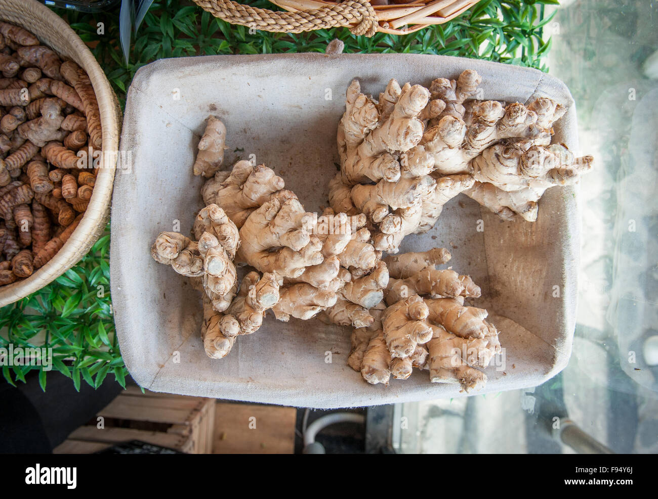 Basket with heap of whole ginger roots on market shelf Stock Photo - Alamy