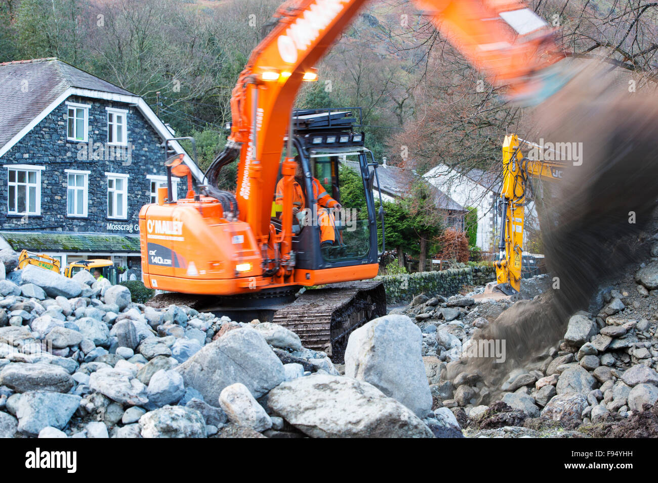 Diggers trying to clear flood debris from flooded river hi-res stock ...