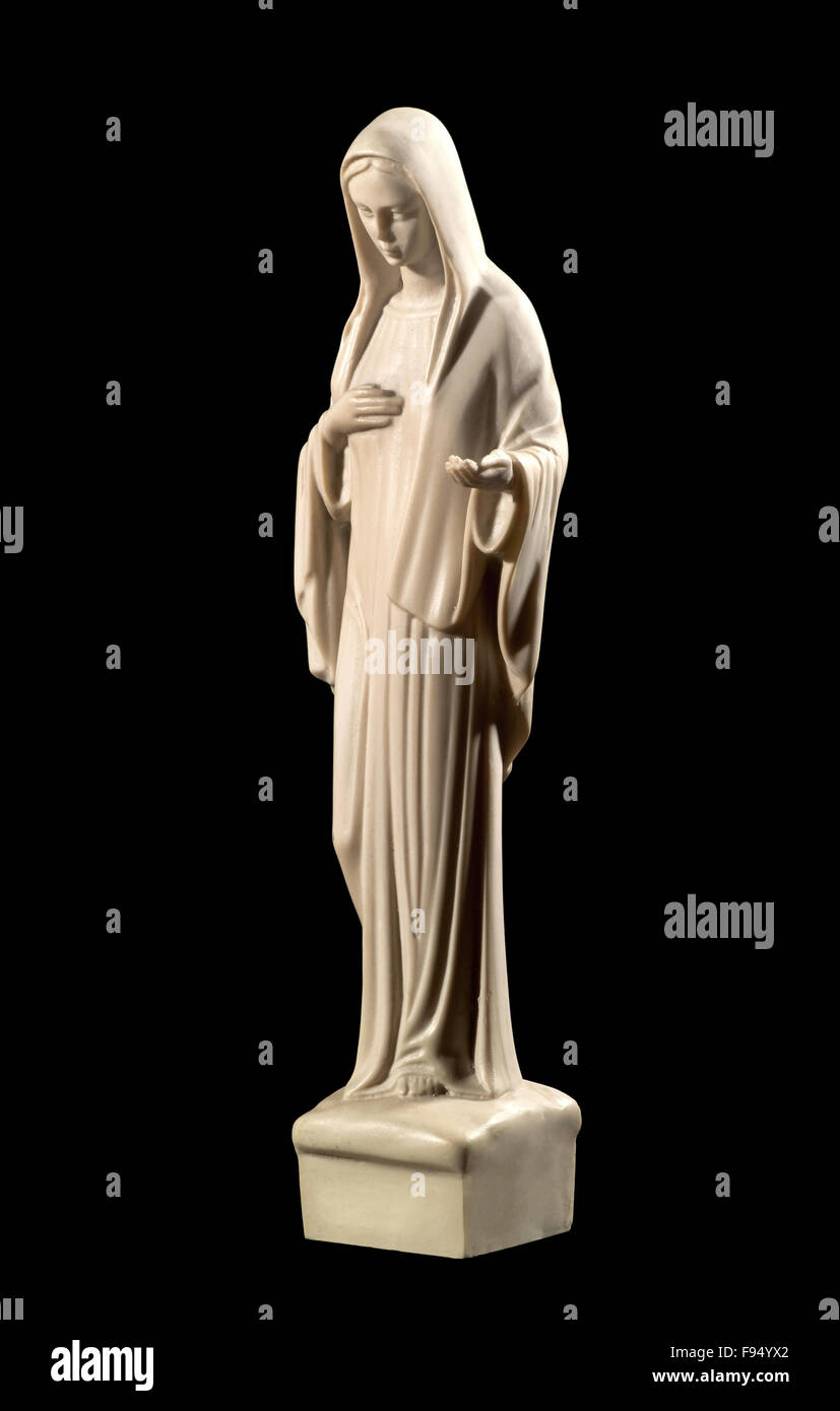 Statue of the Virgin Mary on a black background depicting humility and ...