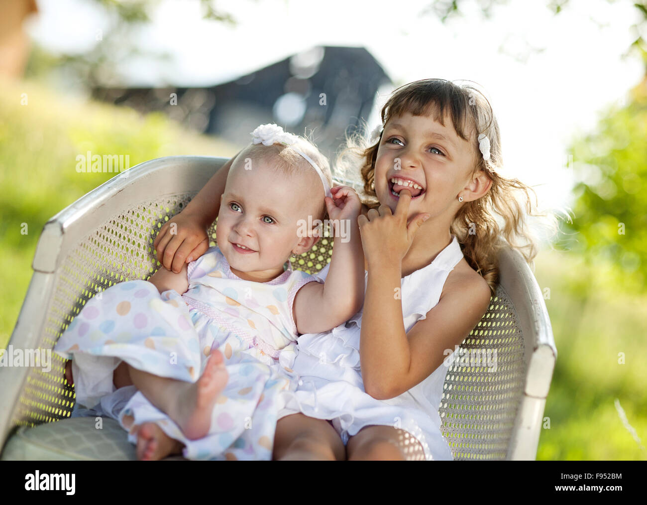 Two cute little sisters laughing and playing in green sunny park Stock ...