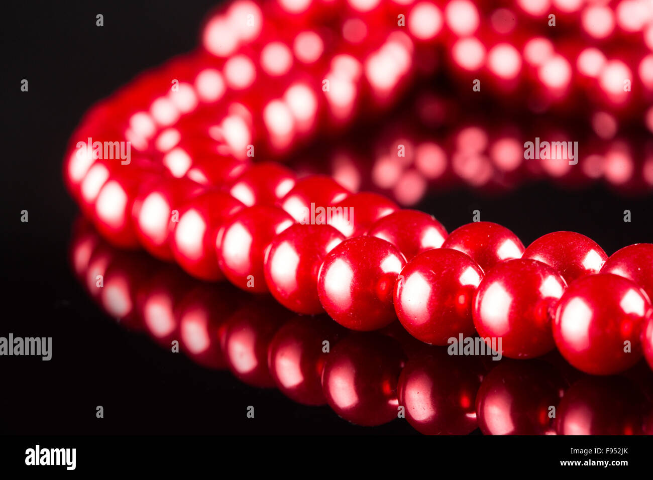 necklace of red pearls on black background Stock Photo - Alamy