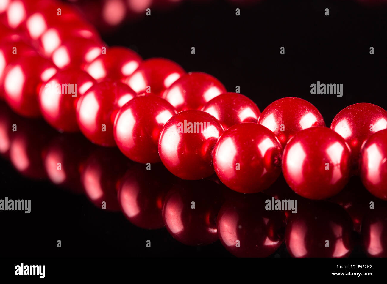 necklace of red pearls on black background Stock Photo - Alamy