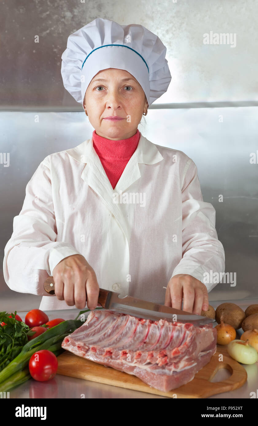 Cook woman with raw meat in kitchen Stock Photo - Alamy