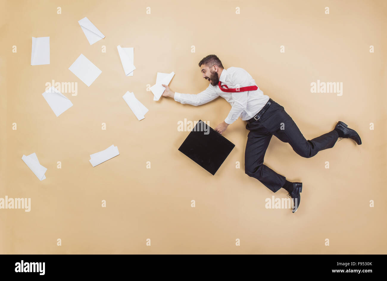 Handsome manager having an accident. Studio shot on a beige background ...