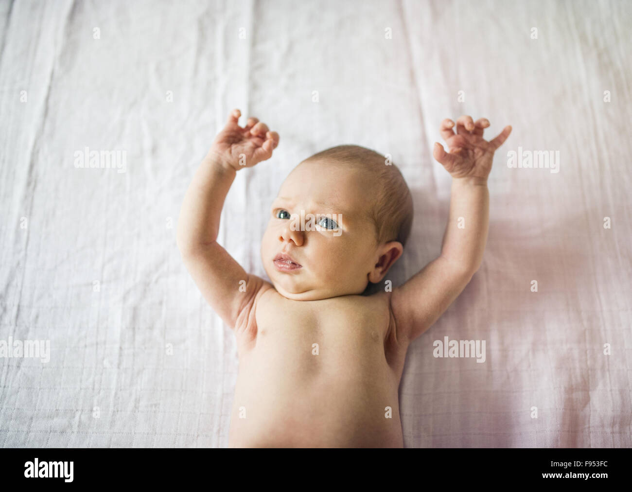 Cute baby is stretching on the bed indoors Stock Photo - Alamy
