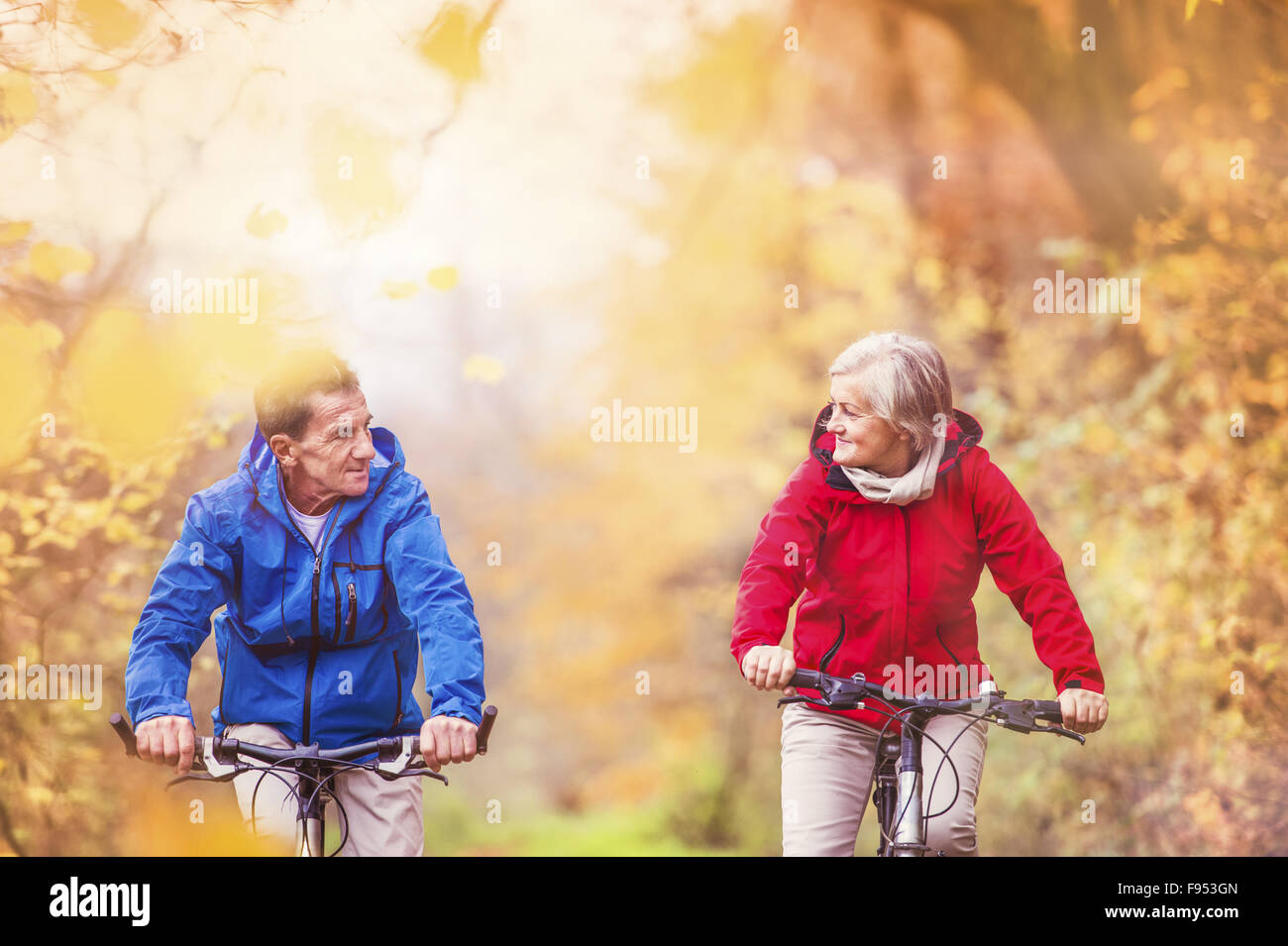 Active seniors riding bike in autumn nature. They relax outdoor Stock ...
