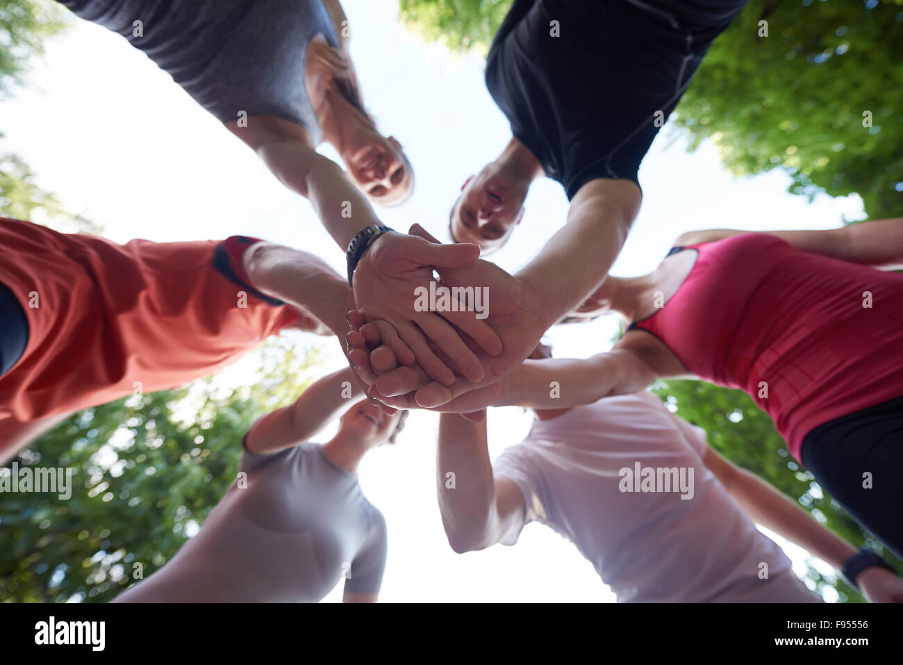 jogging people group, friends have fun, hug and stack hands together ...