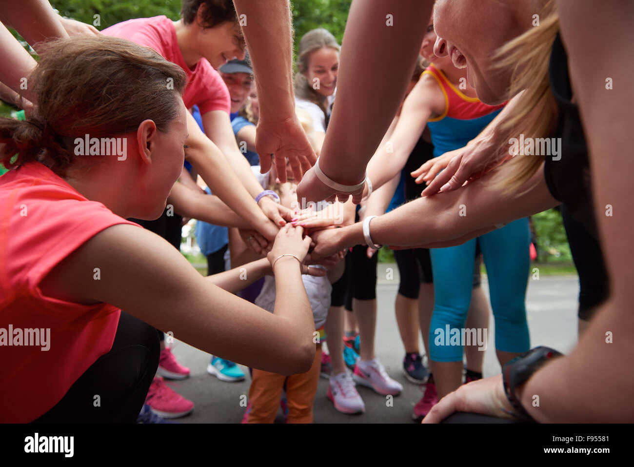 jogging people group, friends have fun, hug and stack hands together ...