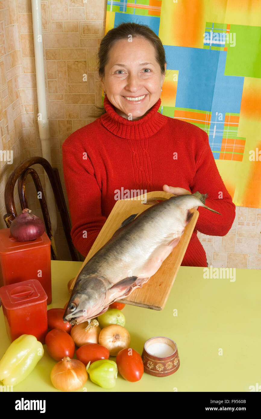 Woman with red fish in her kitchen Stock Photo - Alamy