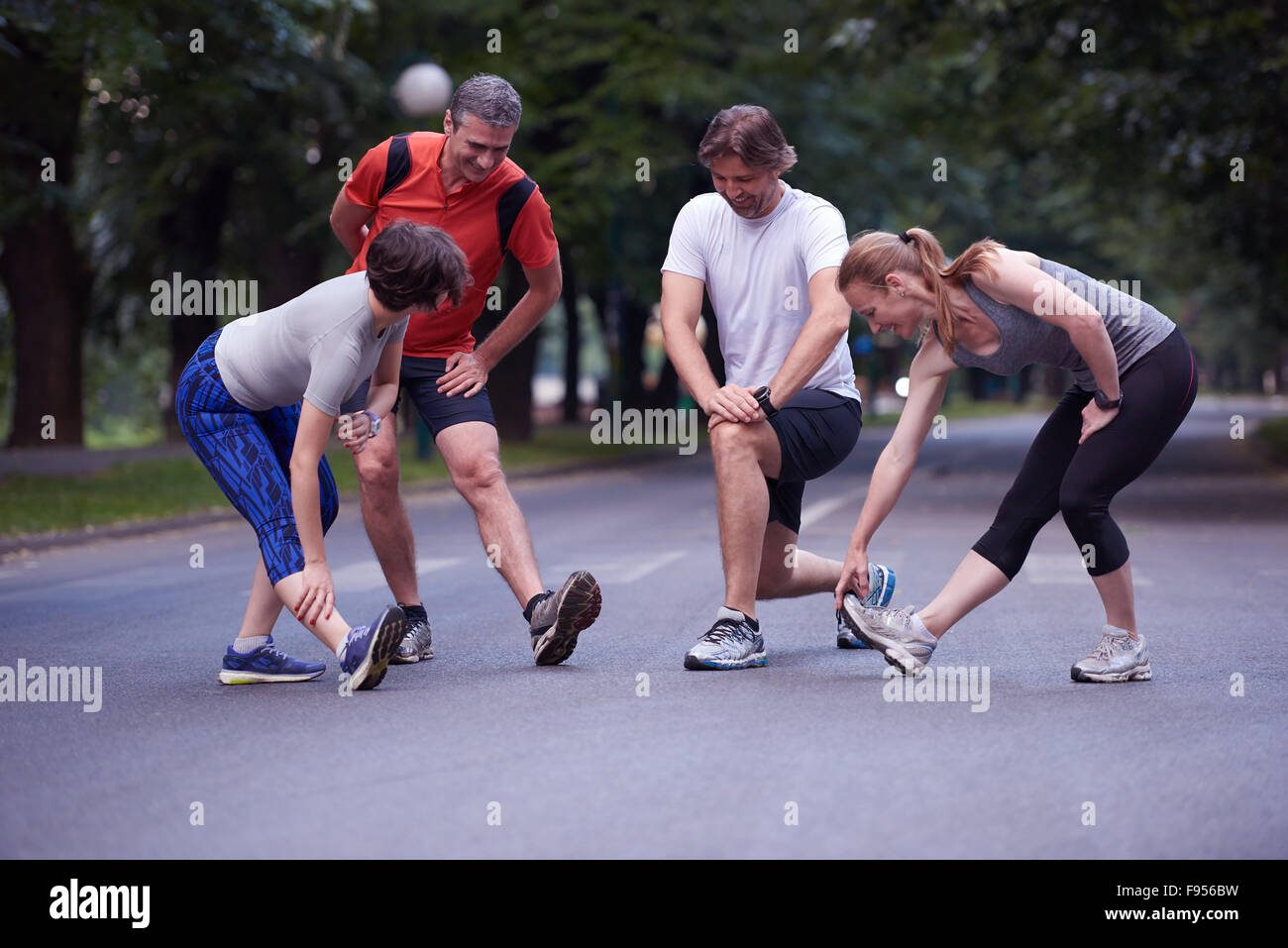 jogging people group stretching in park before training Stock Photo - Alamy
