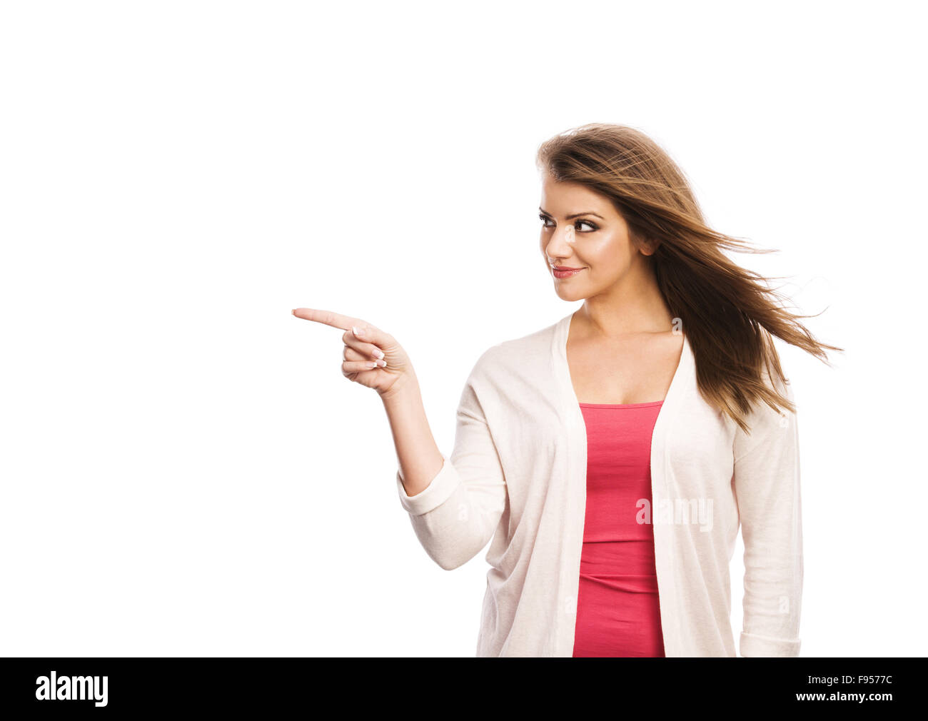 Beautiful young woman pointing to somewhere, isolated over a white ...