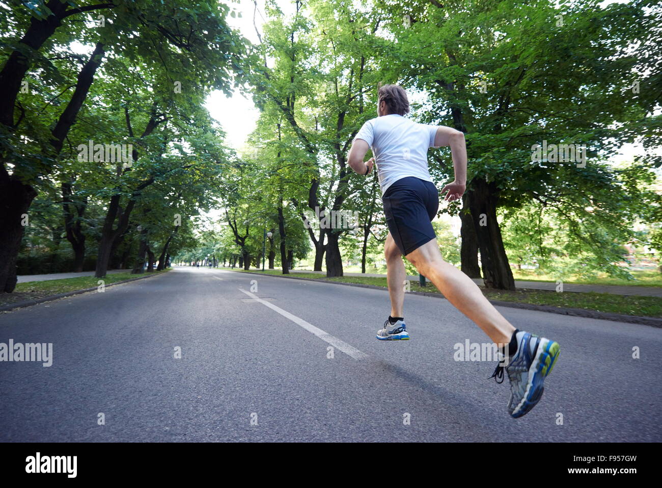 healthy athlete man jogging at morning on empty roat in the city Stock ...