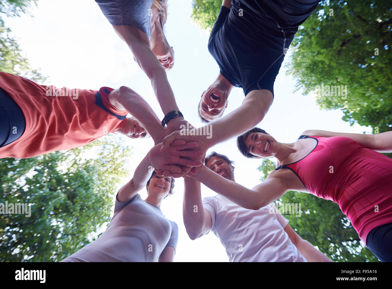 jogging people group, friends have fun, hug and stack hands together ...
