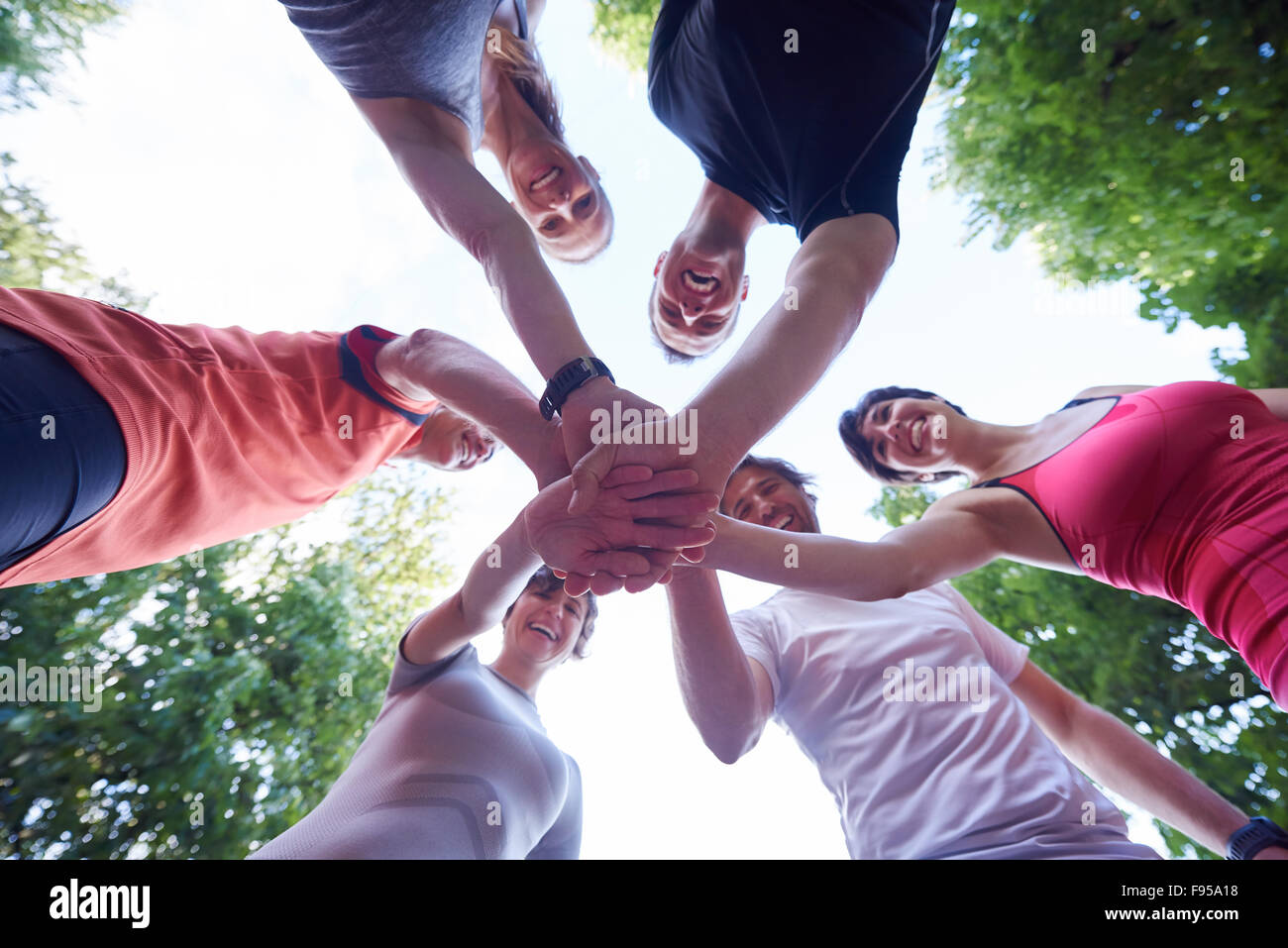 jogging people group, friends have fun, hug and stack hands together ...