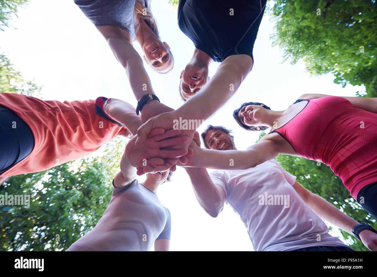 jogging people group, friends have fun, hug and stack hands together ...