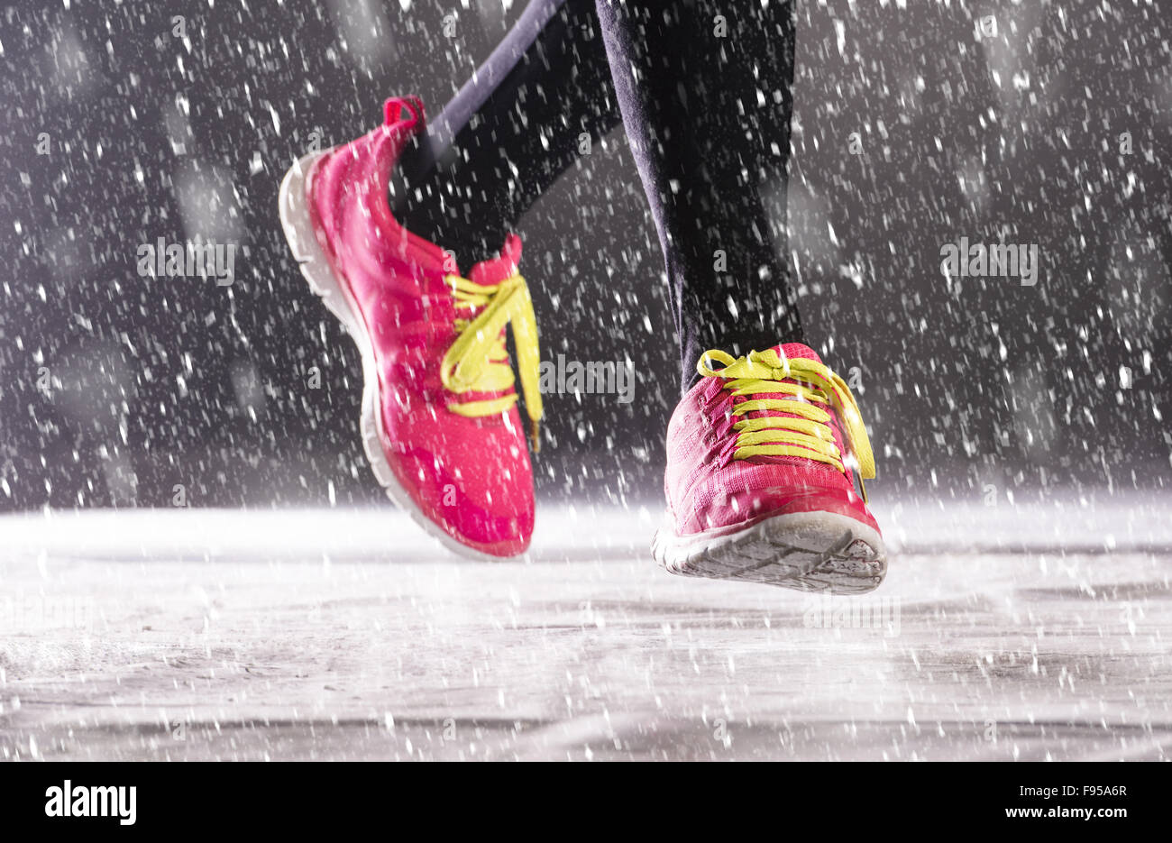 Athlete woman is running during winter training outside in cold snow ...