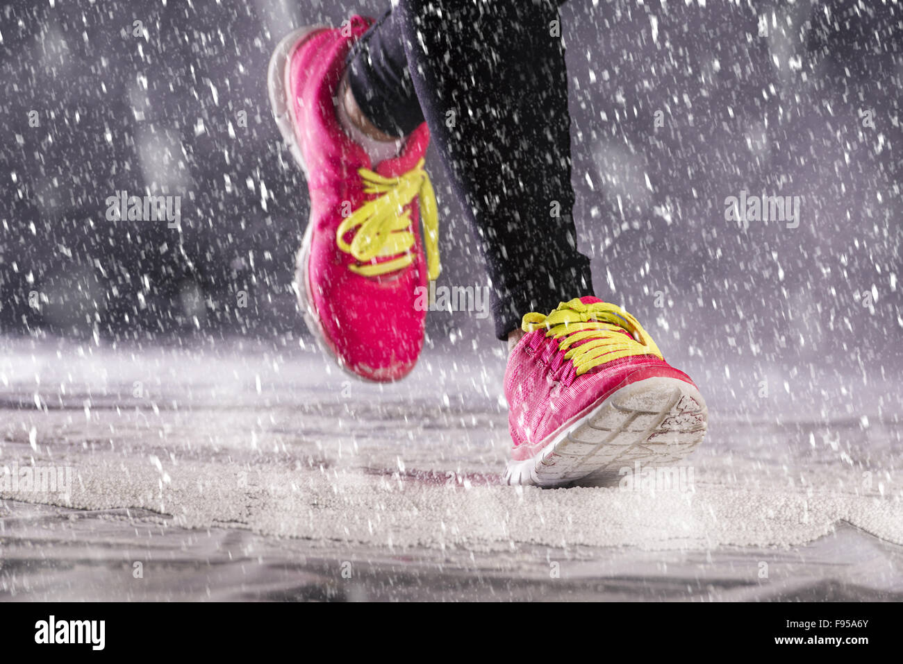 Athlete woman is running during winter training outside in cold snow ...