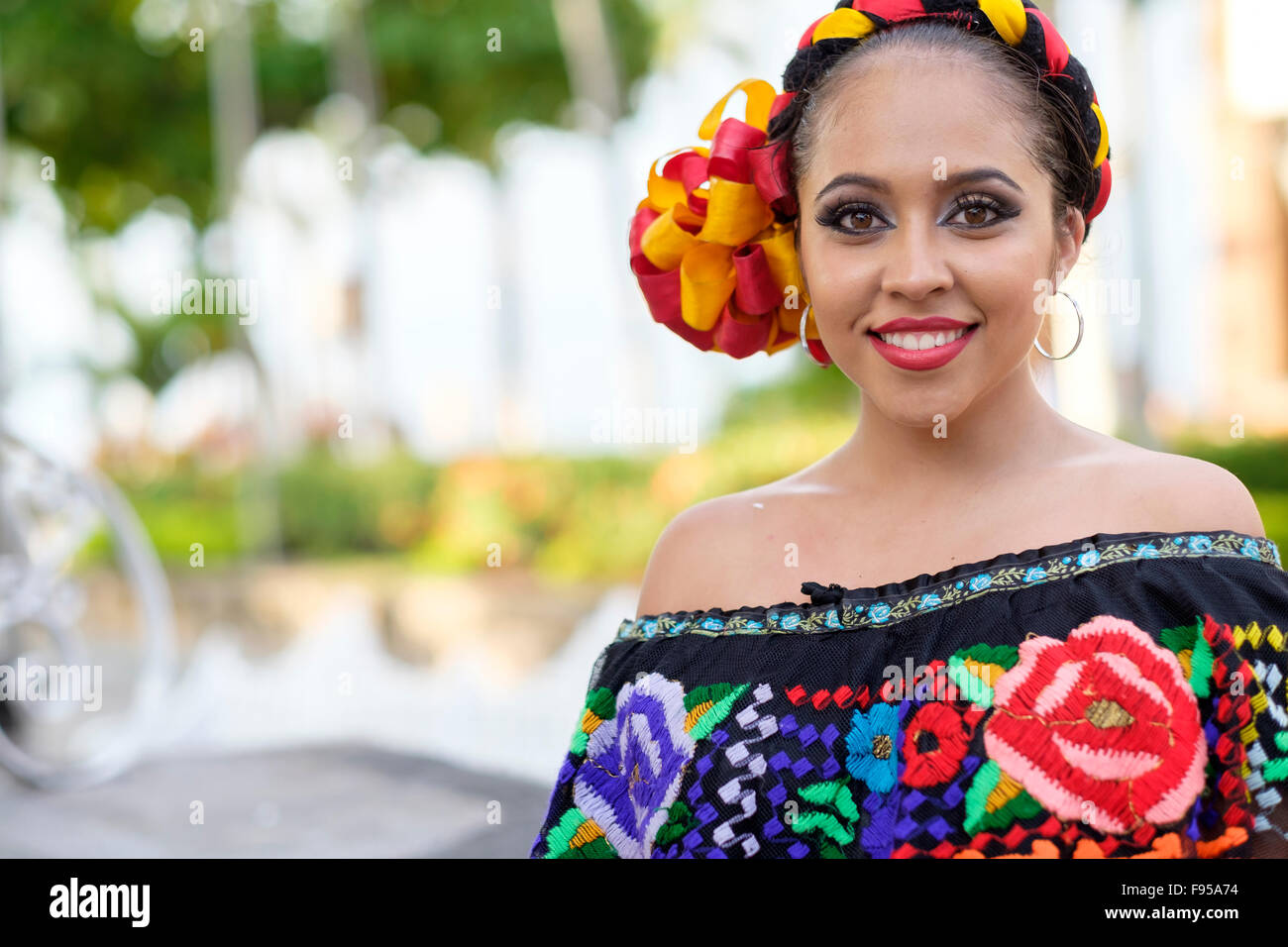 Young woman wearing traditional Mexican costume while smiling at camera ...