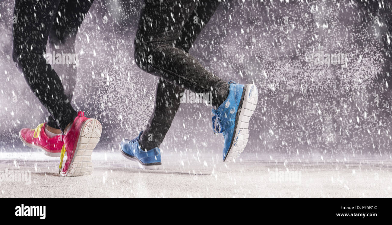 Athlete woman is running during winter training outside in cold snow ...