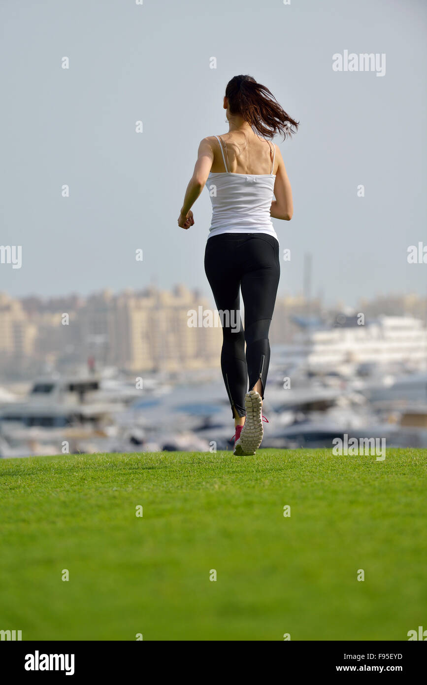Running in city park. Woman runner outside jogging at morning with ...